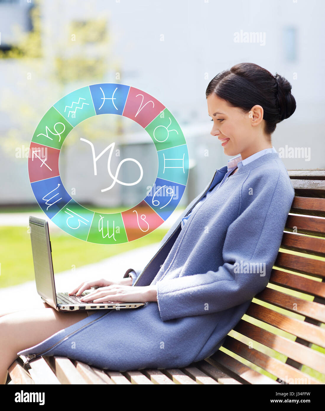 smiling woman with laptop and zodiac signs in city Stock Photo - Alamy