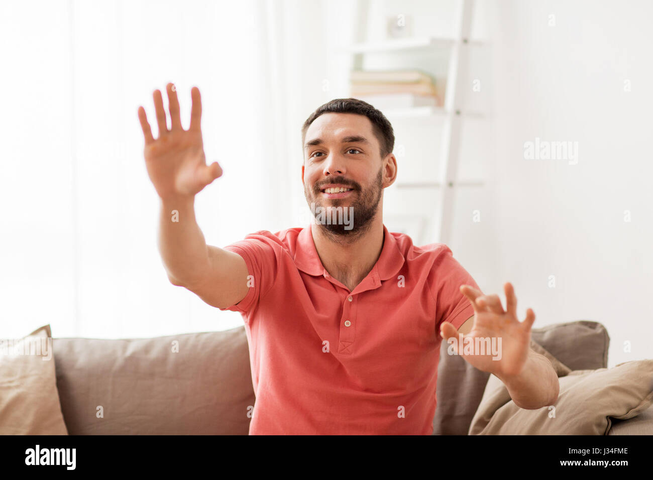 happy man touching something imaginary at home Stock Photo - Alamy