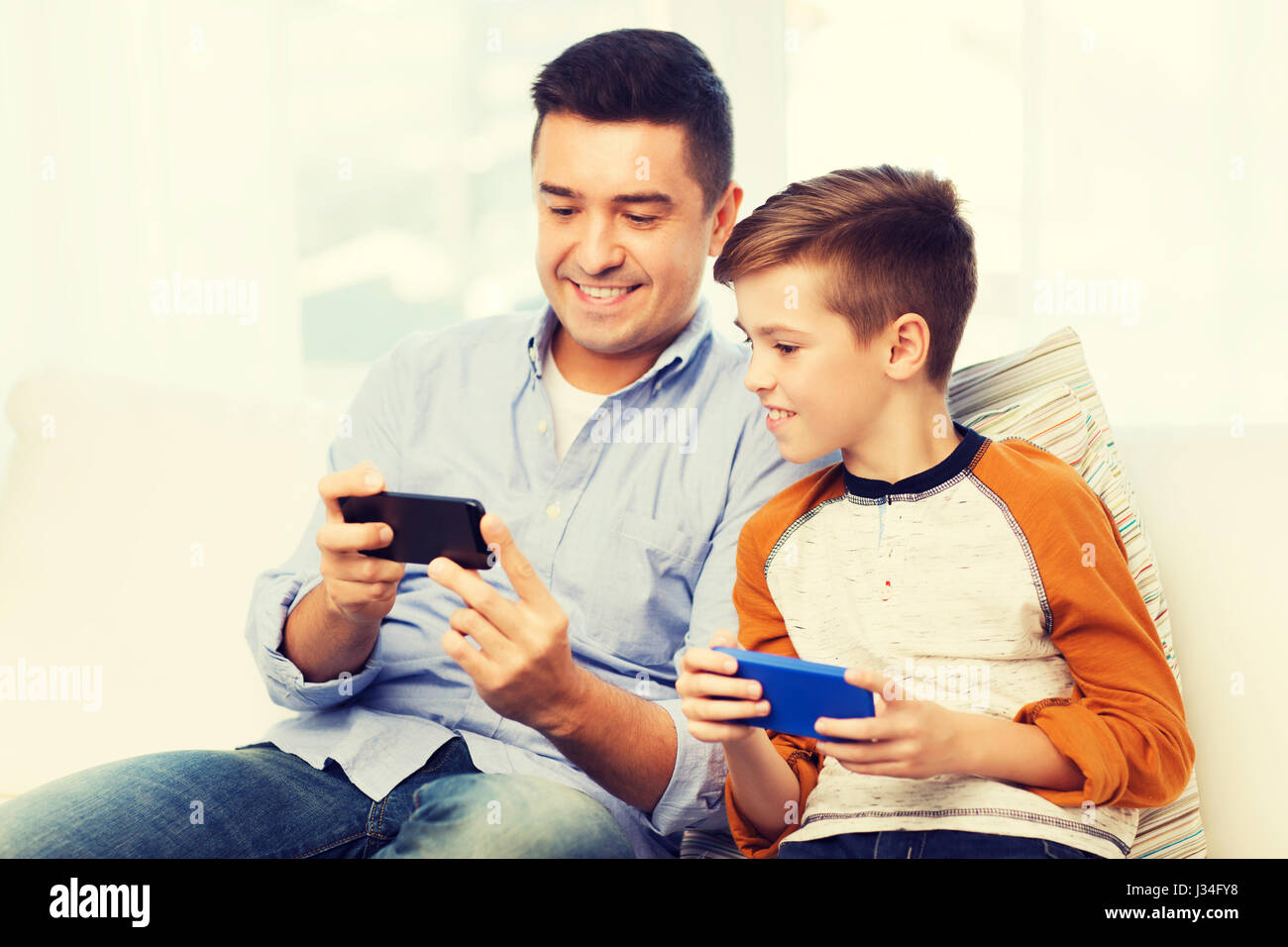 happy father and son with smartphones at home Stock Photo - Alamy