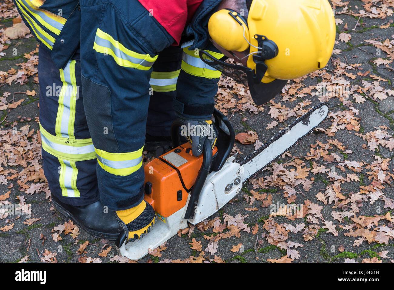 German Fireman in action outdoors with chainsaw Stock Photo - Alamy