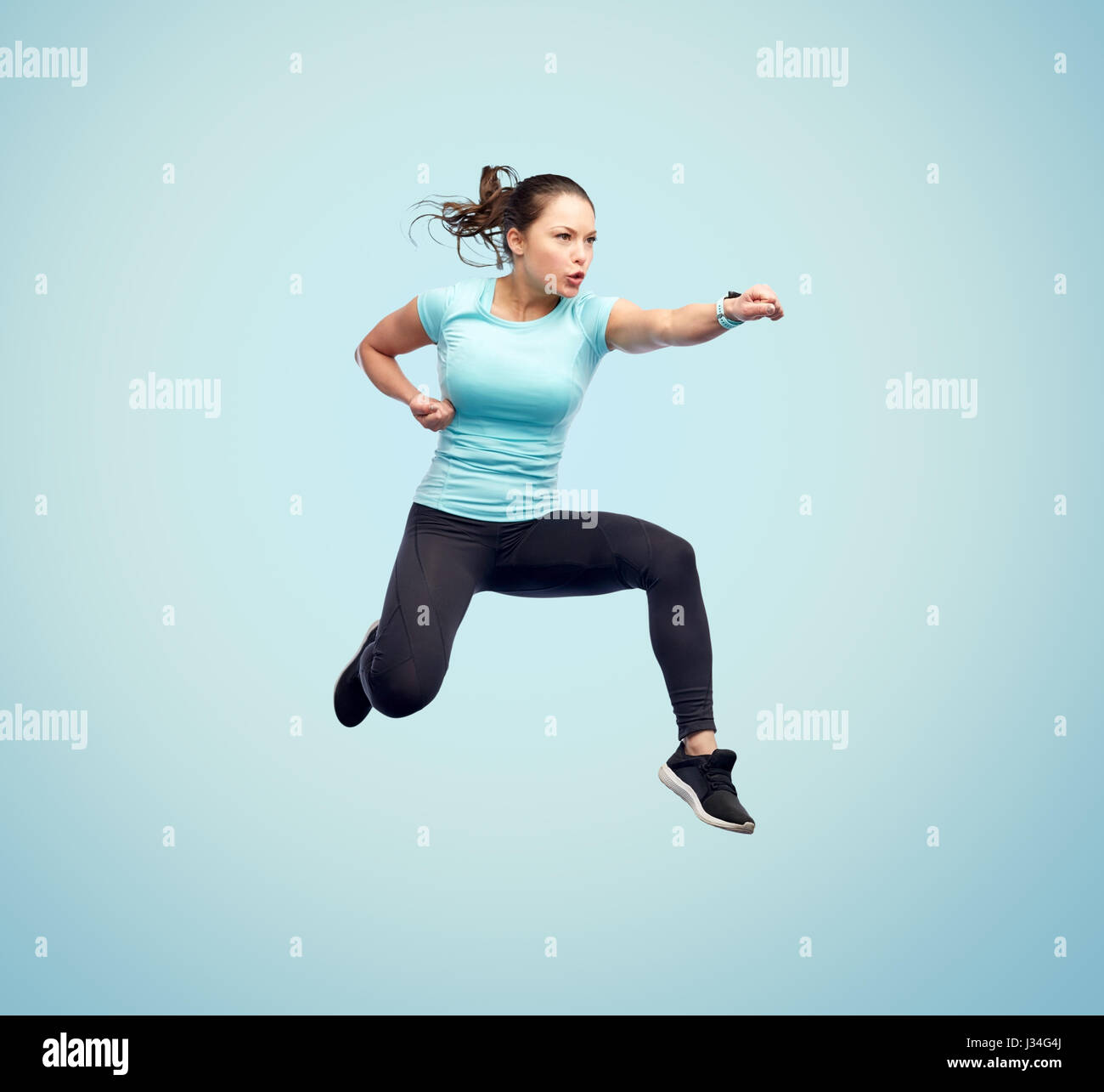 happy sporty young woman jumping in fighting pose Stock Photo - Alamy