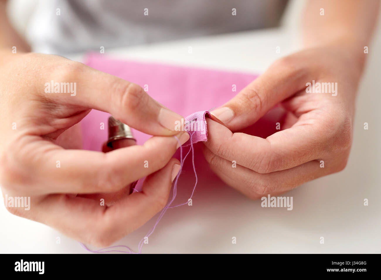 woman with needle stitching fabric pieces Stock Photo - Alamy