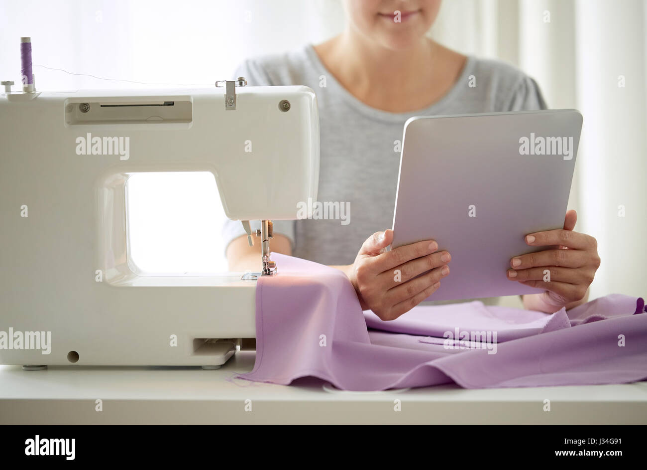 tailor with sewing machine, tablet pc and fabric Stock Photo - Alamy