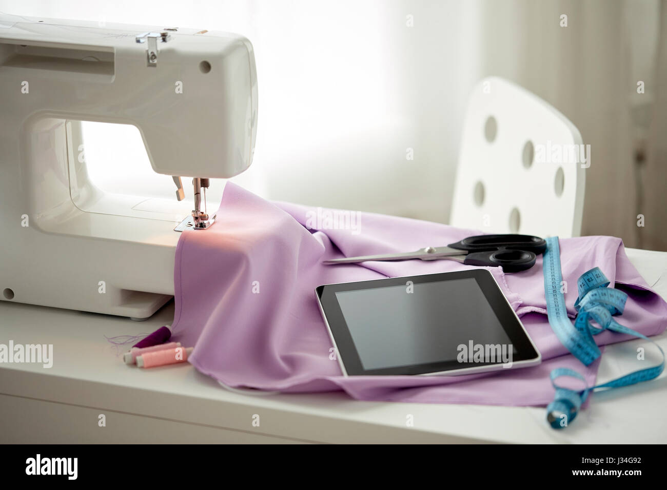 sewing machine, tablet pc, scissors and ruler Stock Photo - Alamy