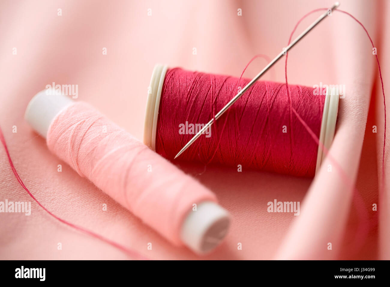 red thread spool on cloth Stock Photo - Alamy