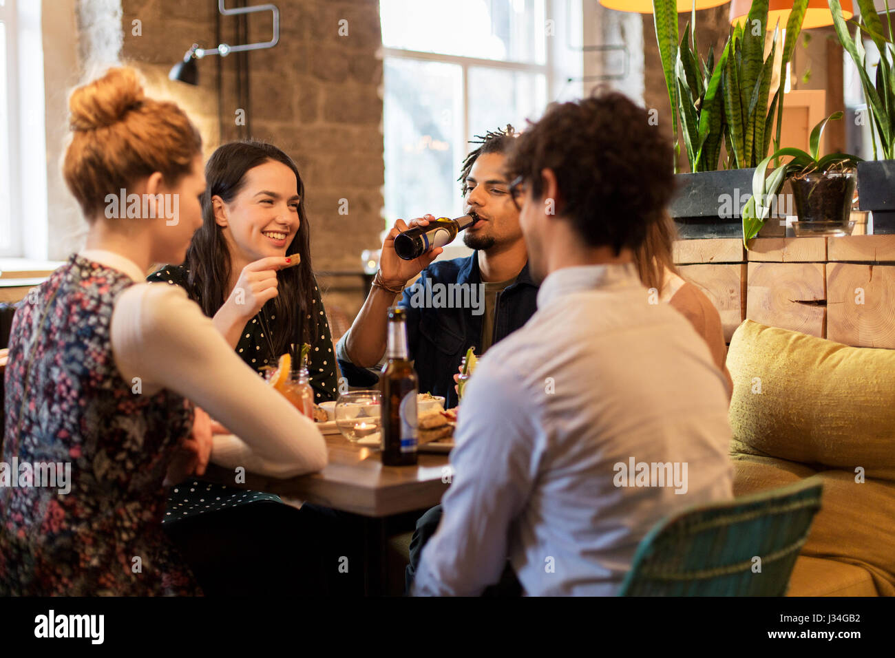 happy friends eating and drinking at bar or cafe Stock Photo - Alamy