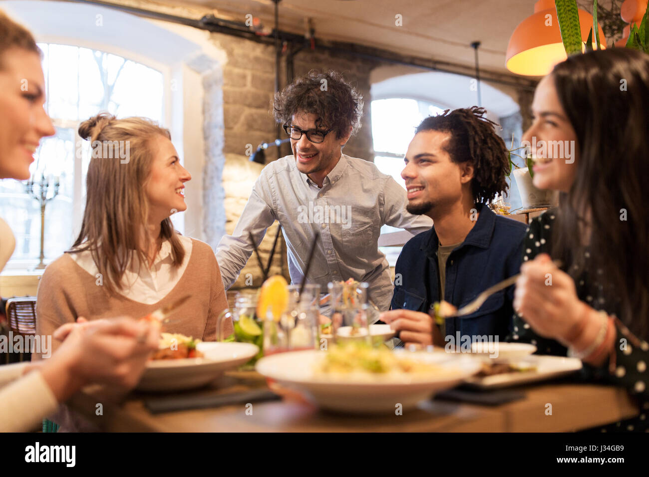 happy friends eating and drinking at restaurant Stock Photo - Alamy