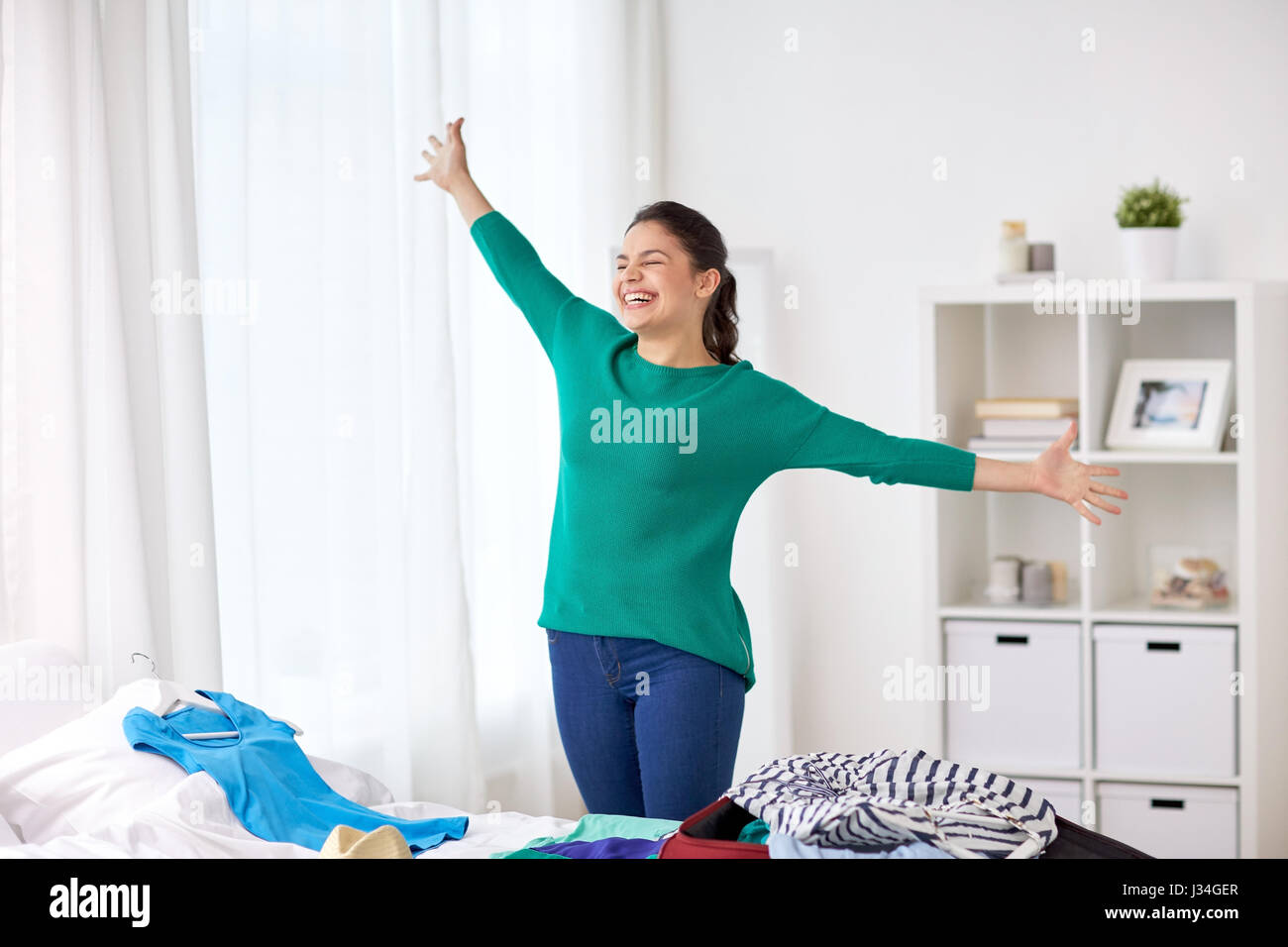 happy woman packing travel bag at home Stock Photo - Alamy