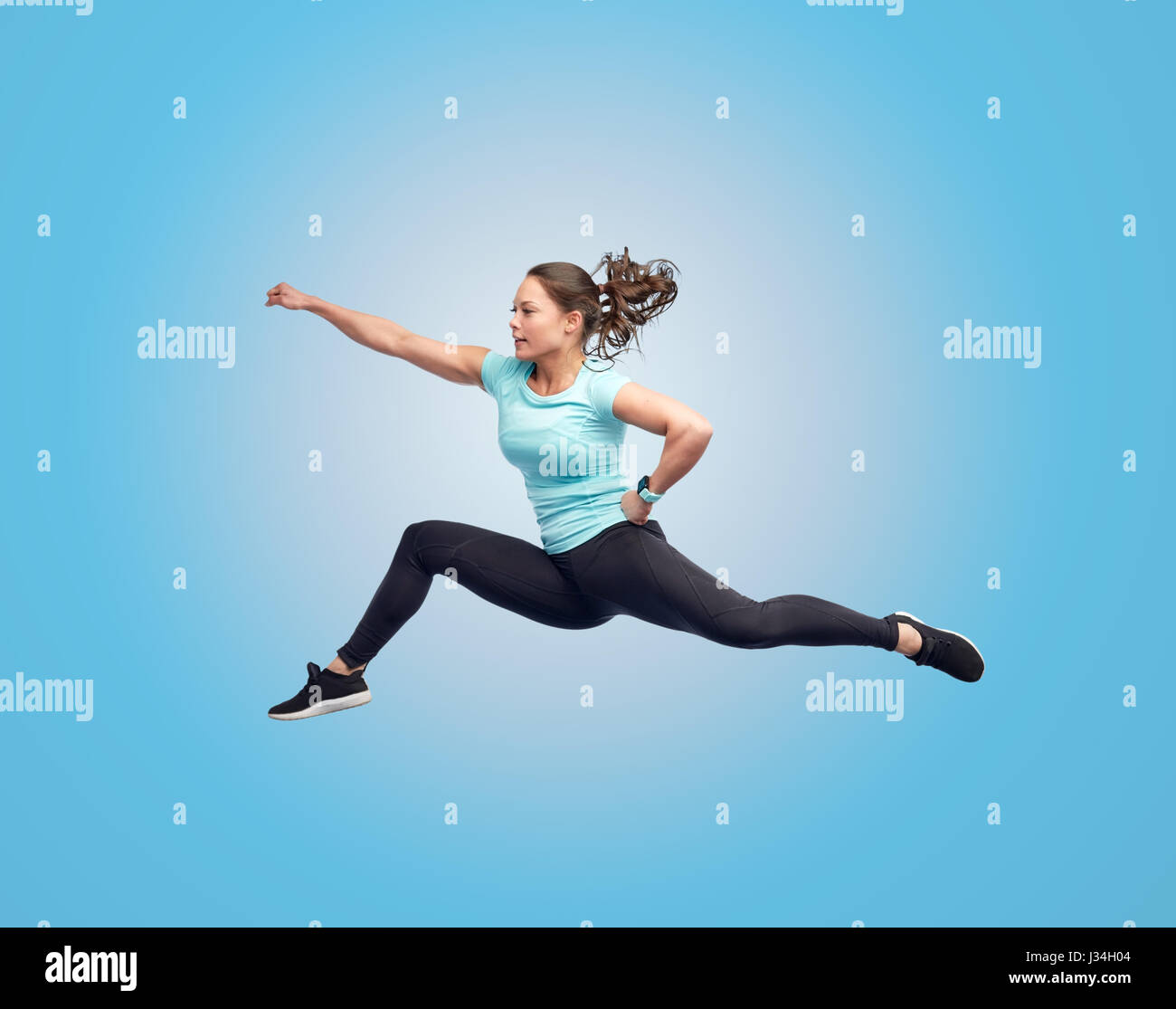 happy sporty young woman jumping in fighting pose Stock Photo - Alamy