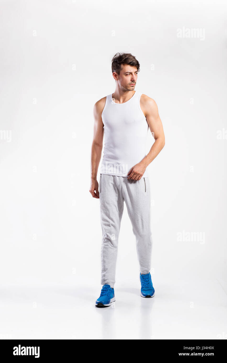 Handsome fitness man in white tank top shirt, studio shot Stock Photo ...