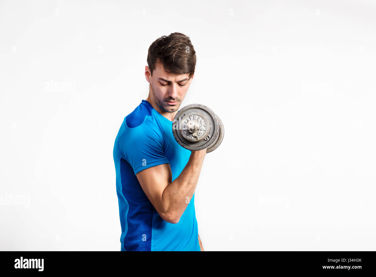 Fitness man holding dumbbell, working out, studio shot Stock Photo - Alamy