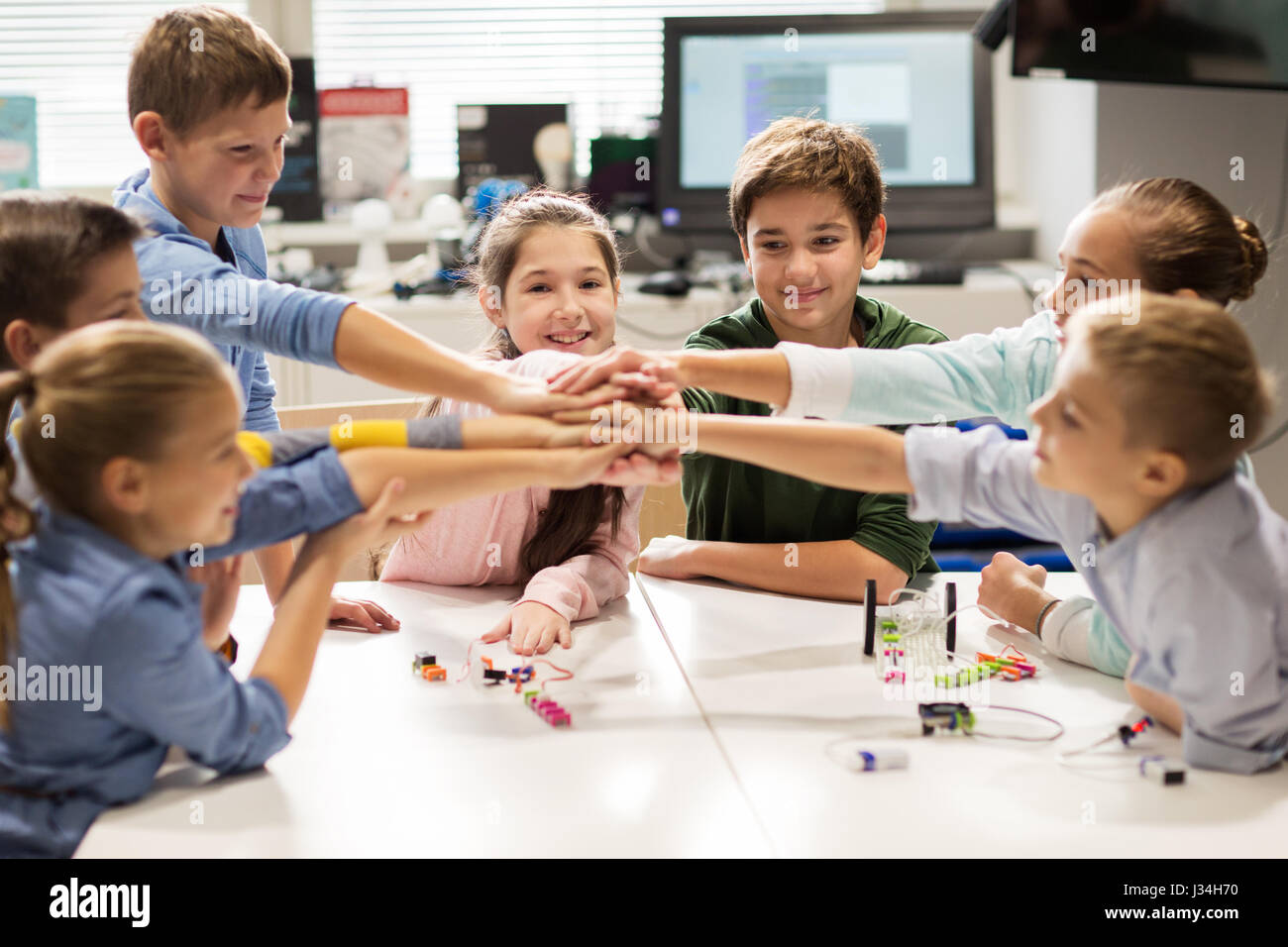 happy children holding hands at robotics school Stock Photo - Alamy