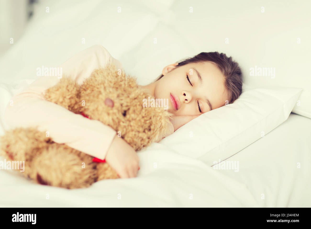 girl sleeping with teddy bear toy in bed at home Stock Photo - Alamy