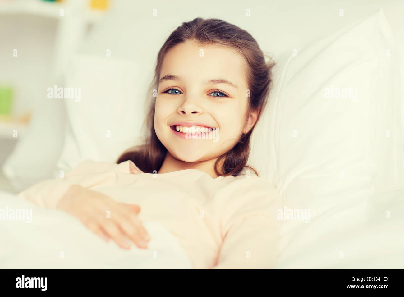 happy smiling girl lying awake in bed at home Stock Photo - Alamy