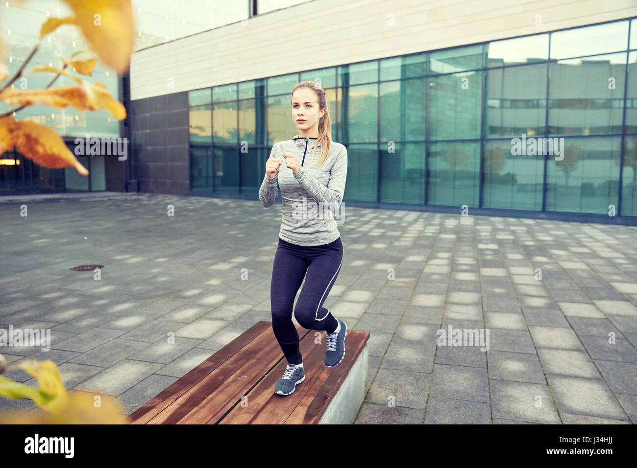 woman making step exercise on city street bench Stock Photo - Alamy