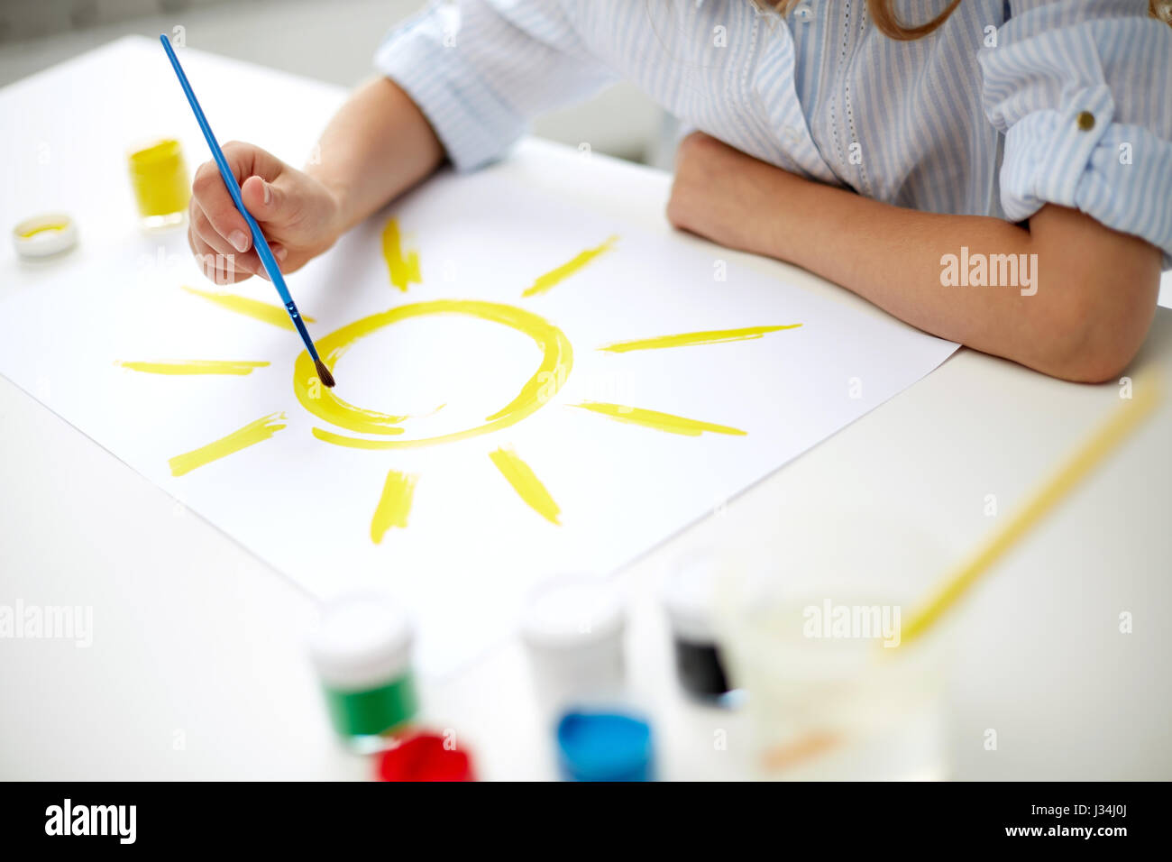 girl with brush drawing sun on paper Stock Photo - Alamy