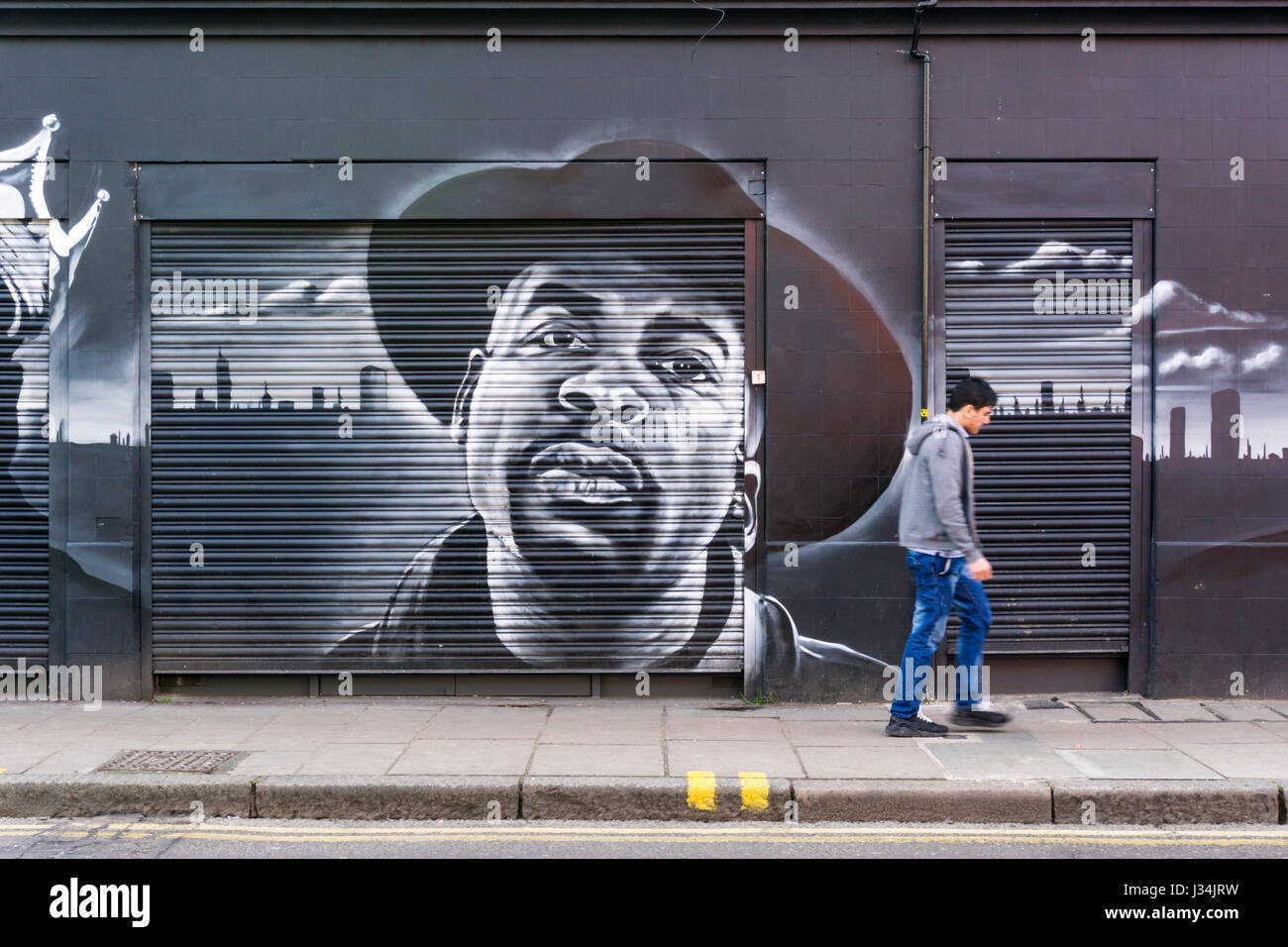 Man, motion blurred, walking past mural in Coldharbour Lane, Brixton ...