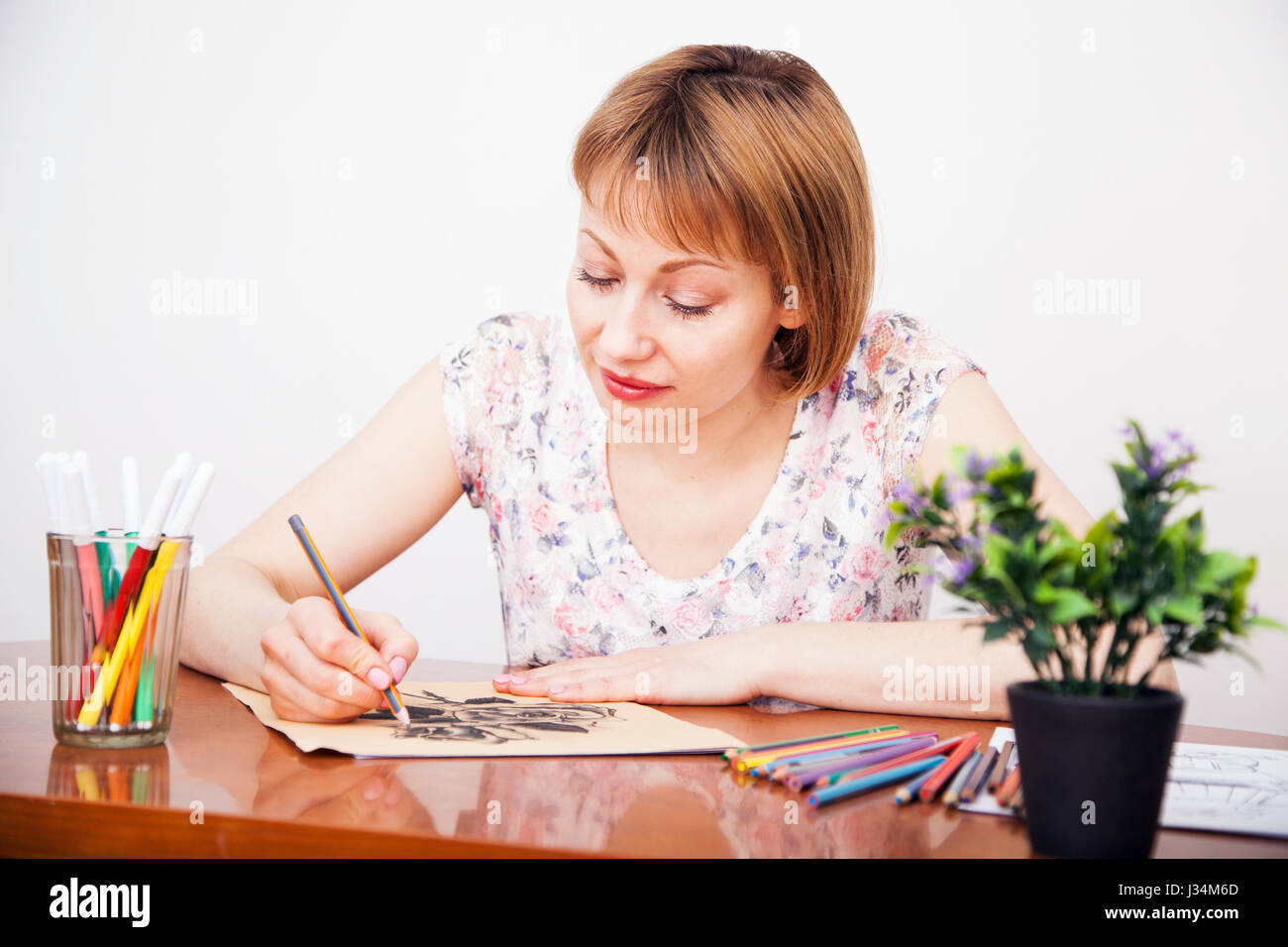 Young woman drawing at the desk Stock Photo - Alamy