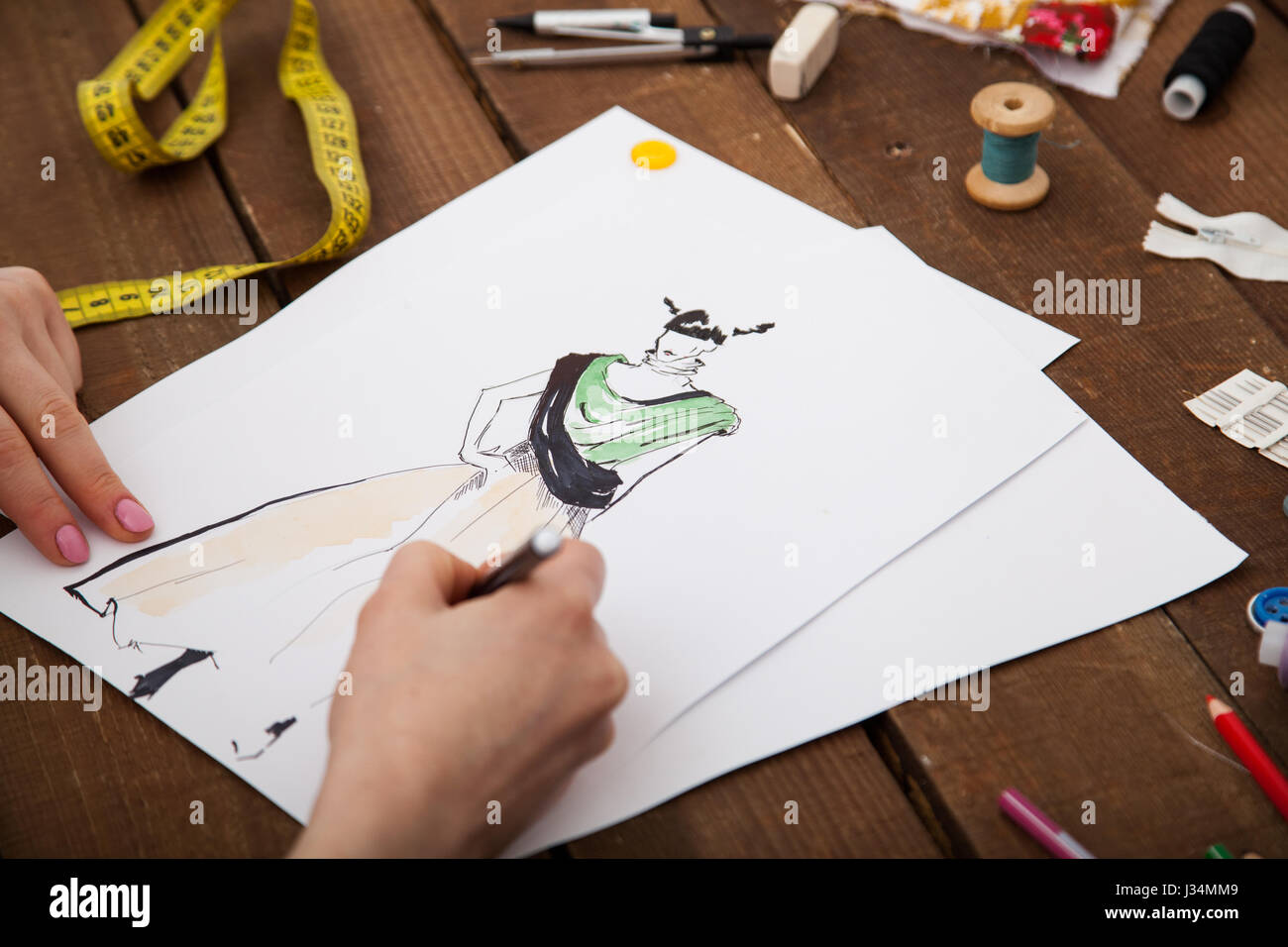 Fashion designer drawing new models of clothes Stock Photo - Alamy