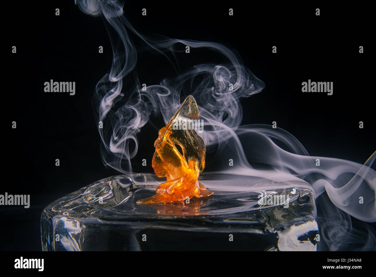 Melted cannabis oil concentrate aka shatter with smoke isolated over ...