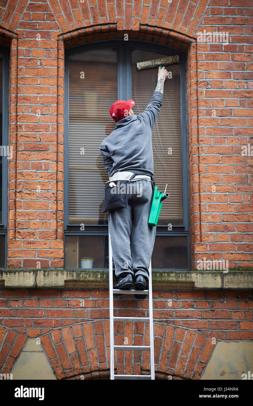 Manchester city centre apartment window cleaner on ladders Stock Photo ...