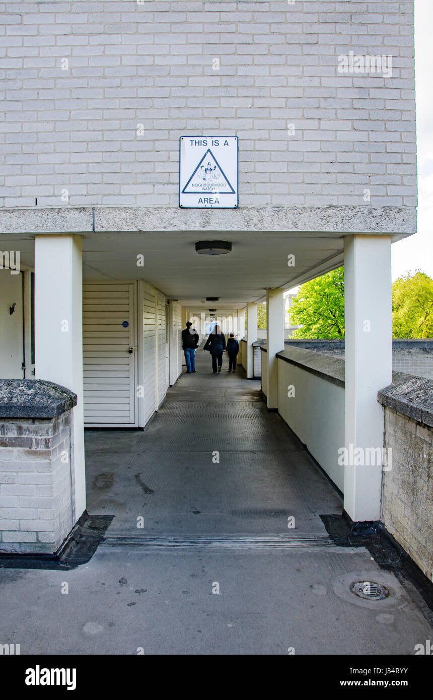 People walking down a walkway which runs along the edge of a block of ...