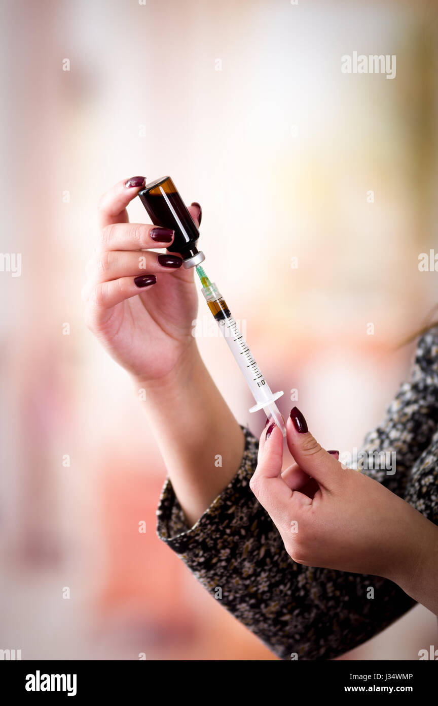 Young woman with syringe is preparing the substance to inject Stock ...
