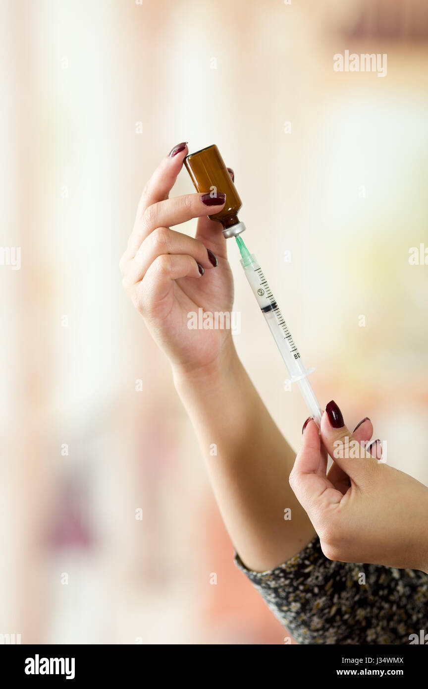 Young woman with syringe is preparing the substance to inject Stock ...