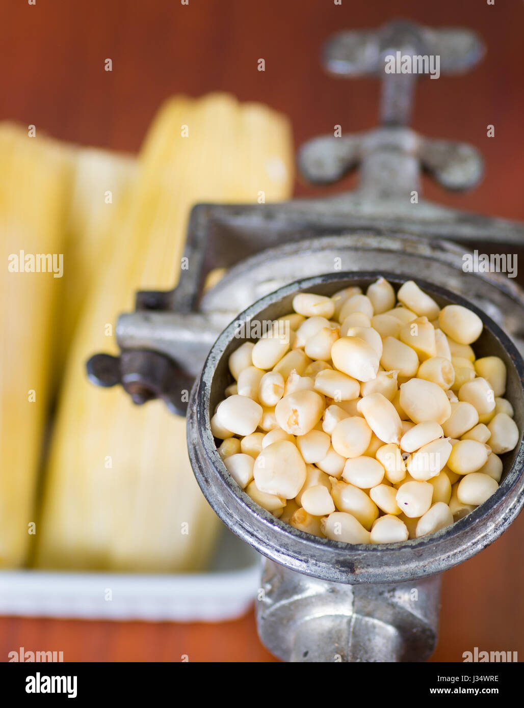 A close up from a metalic mill with some corn kernels Stock Photo - Alamy