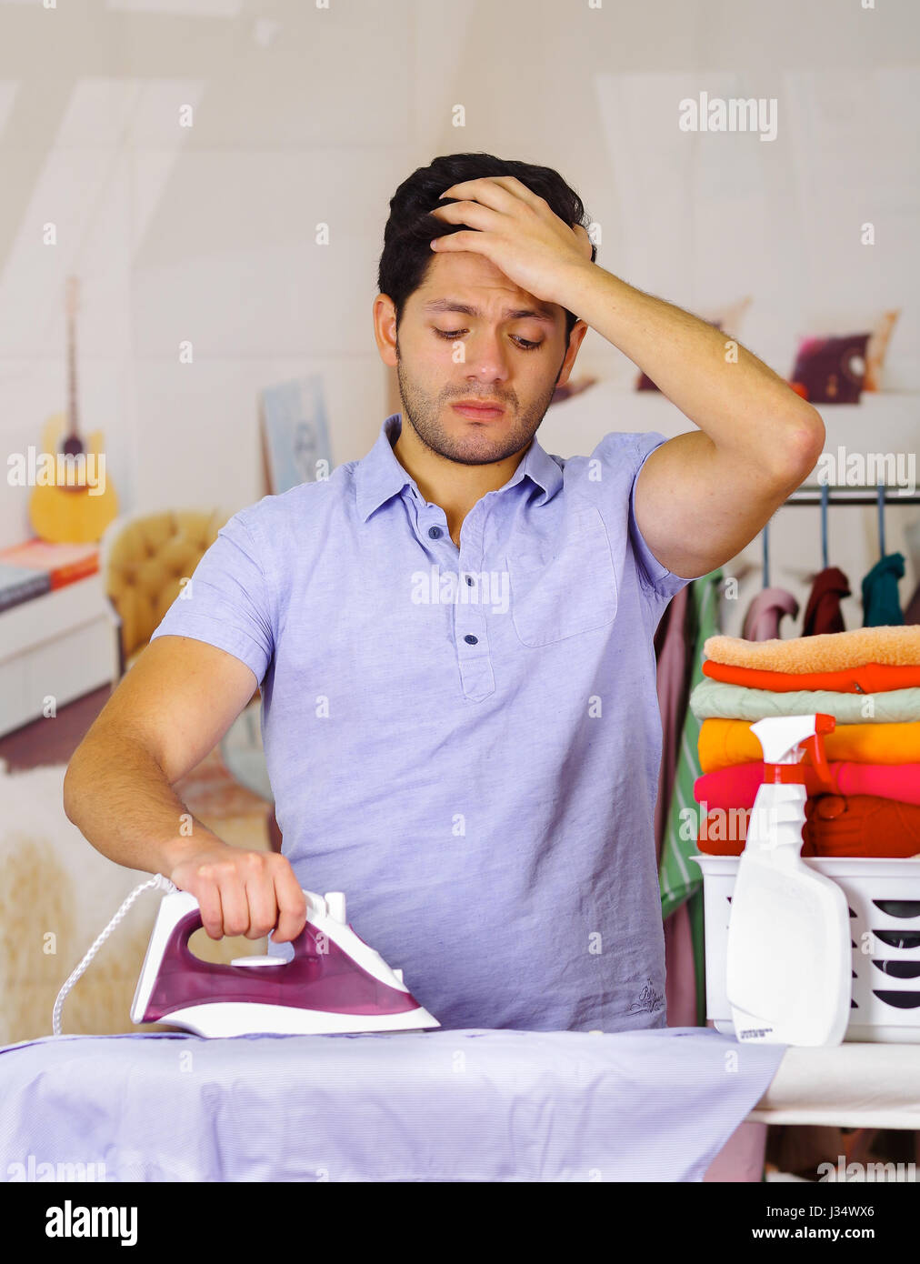Handsome young worried Man Ironing Clothes On Ironing Board Stock Photo ...