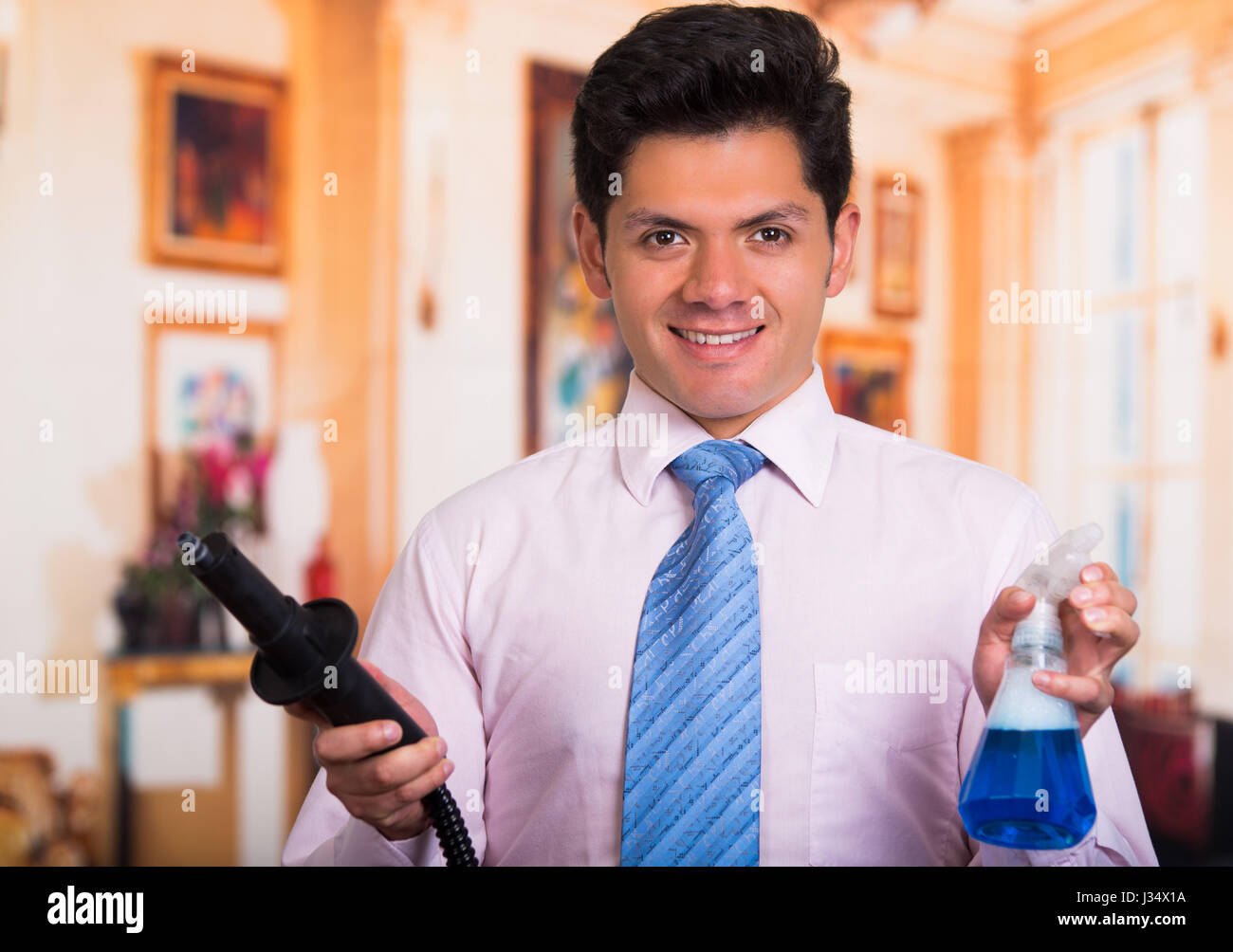 Handsome young Man cleaning home with vacuum cleaner with a ...