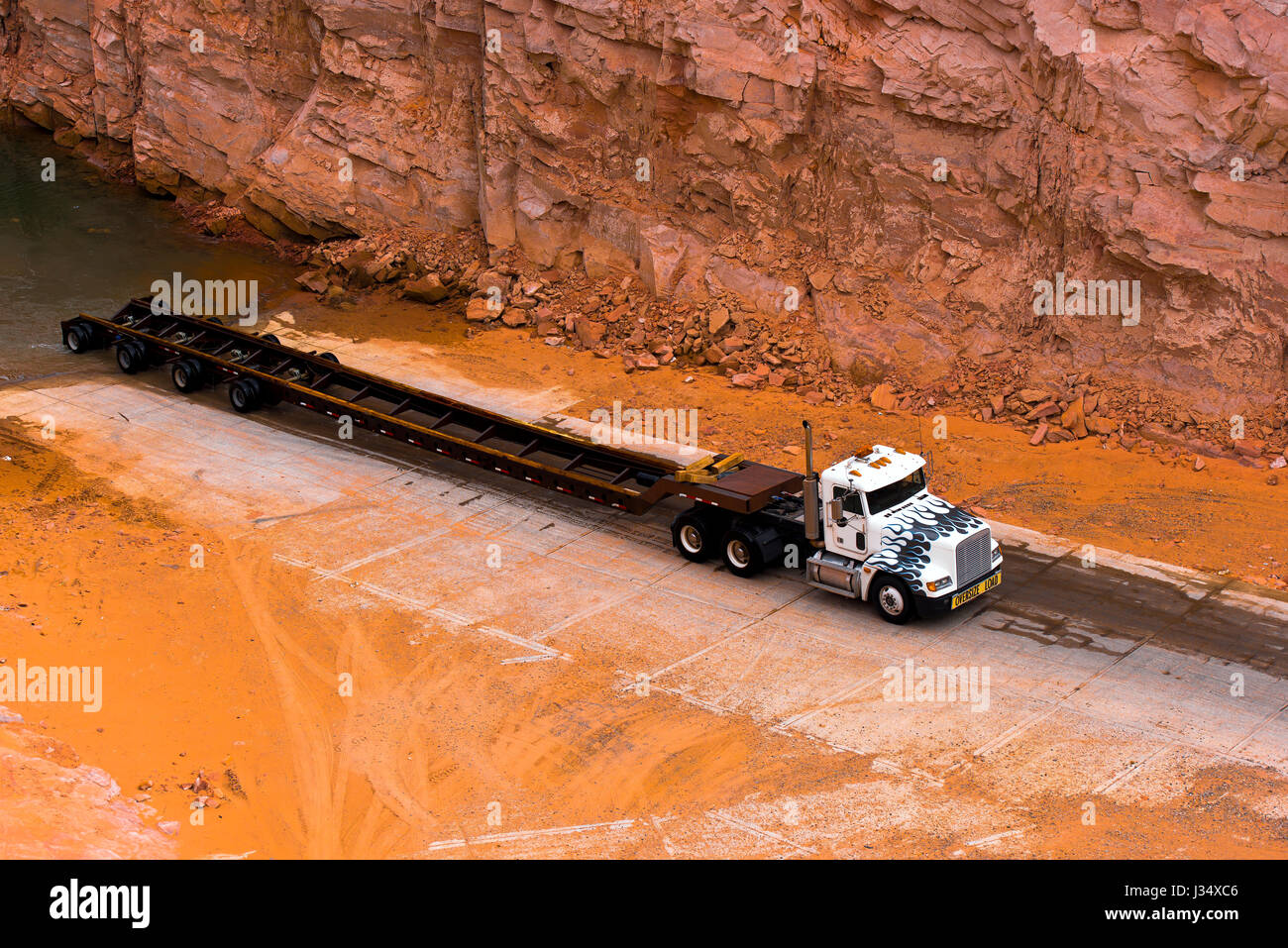 Big truck with a long trailer of two metal sections with four axles for ...
