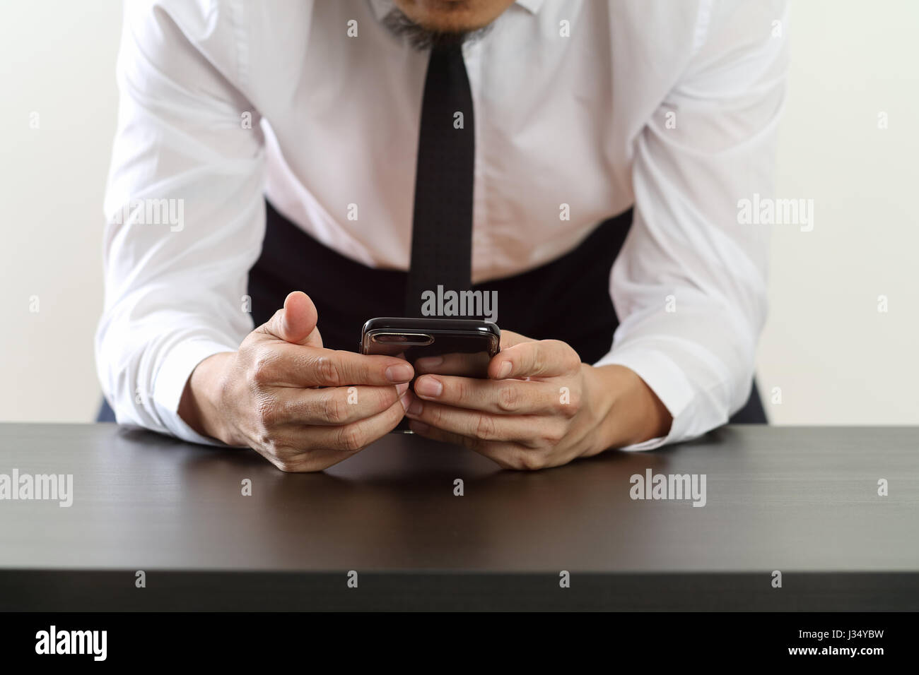close up of businessman working with mobile phone and sitting on the ...