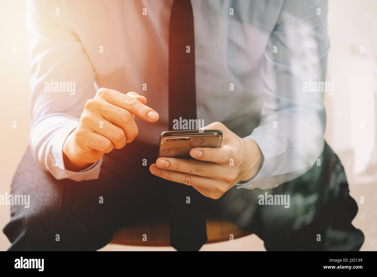 close up of businessman working with mobile phone and sitting on the ...
