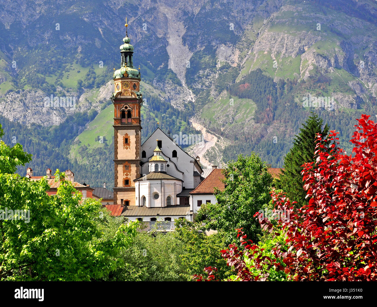 Church with bell tower, colorful leaves and mountains. Austrian ...