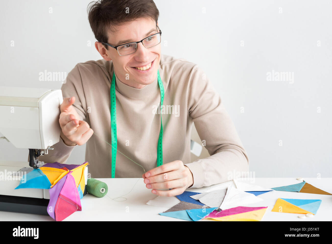quilting and needlework - handsome young male thread a needle, on his ...