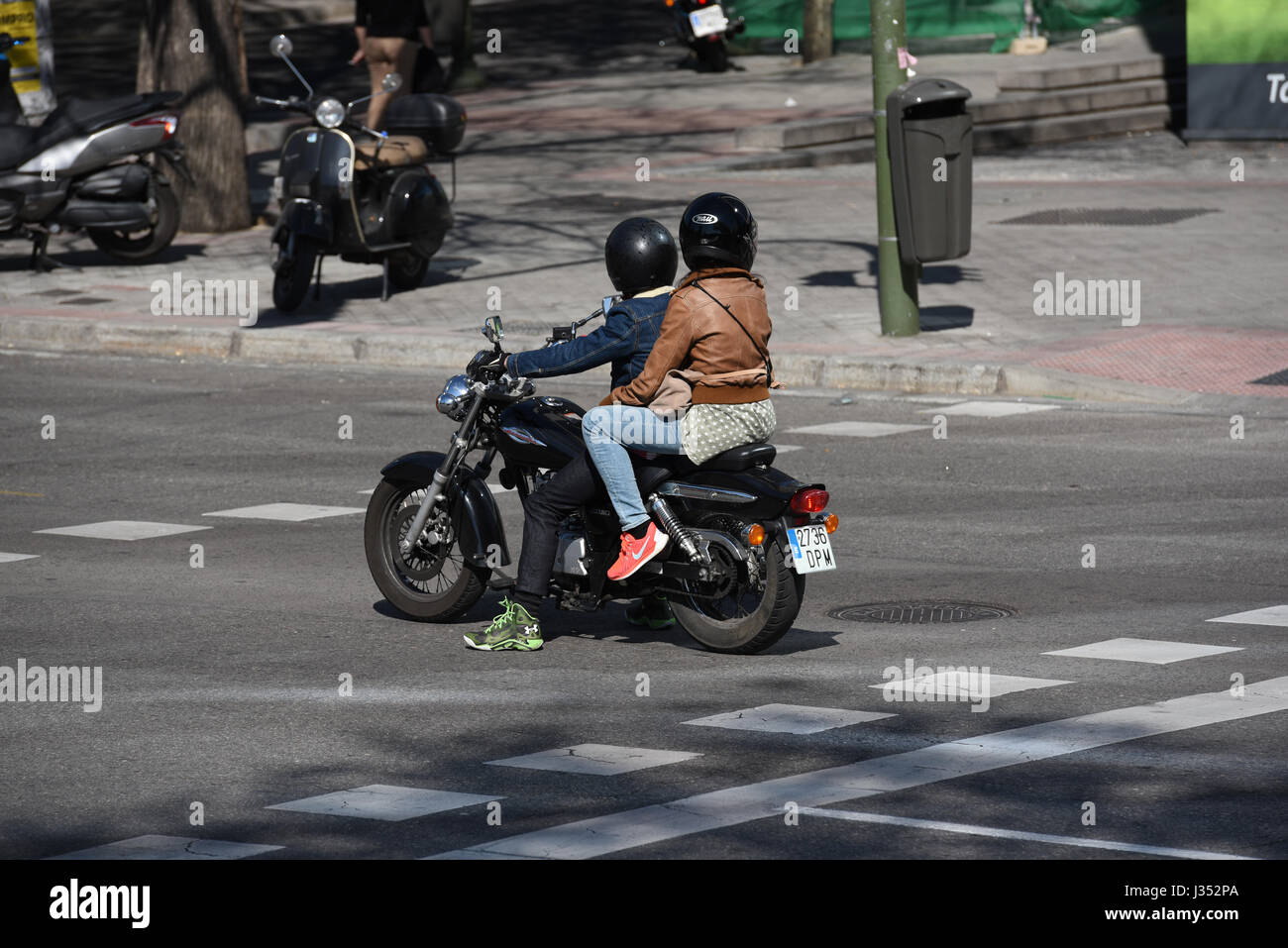 Two people with helmets on the motorcycle Stock Photo - Alamy