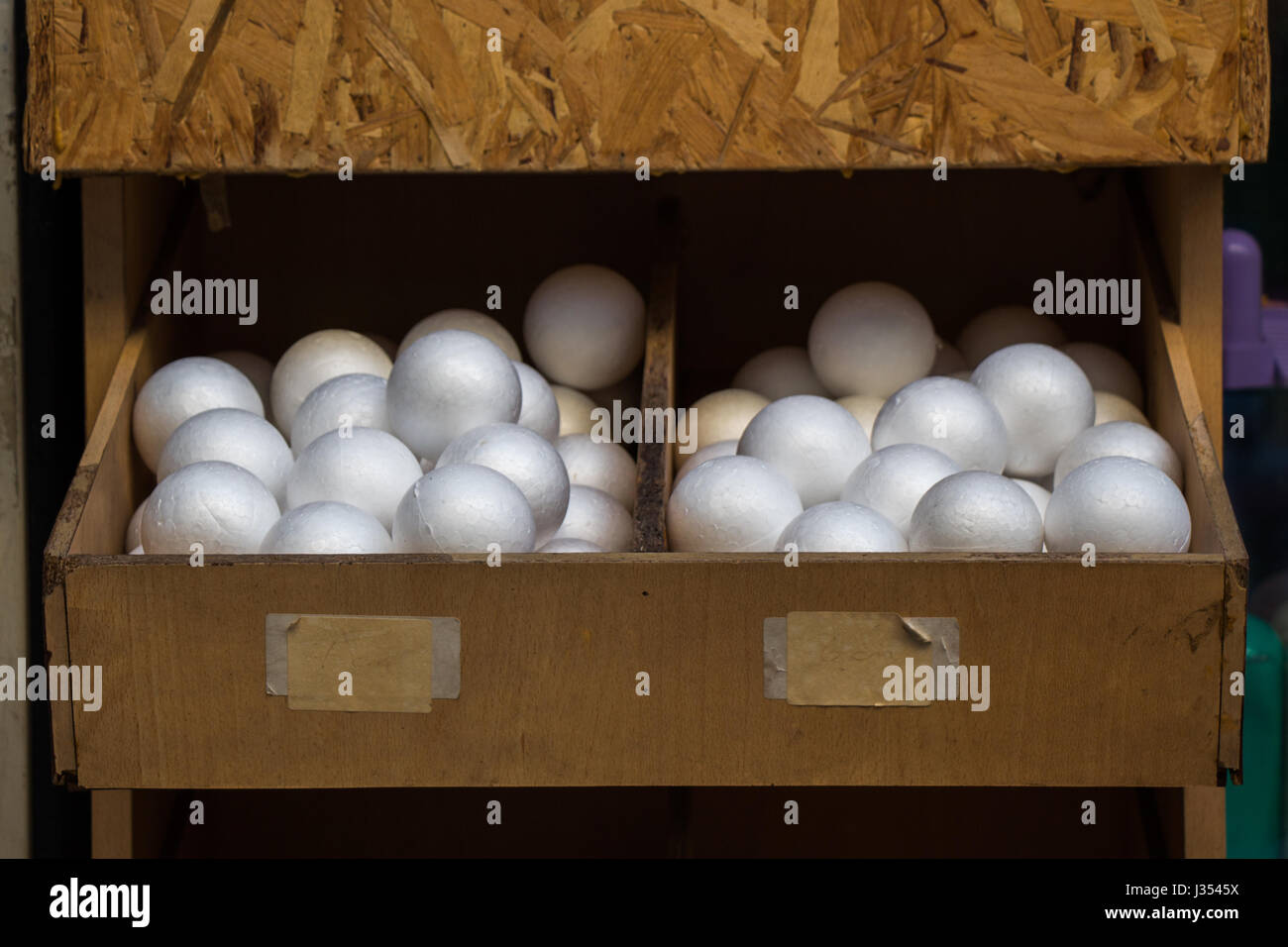 Plenty of white color balls in the drawer Stock Photo - Alamy