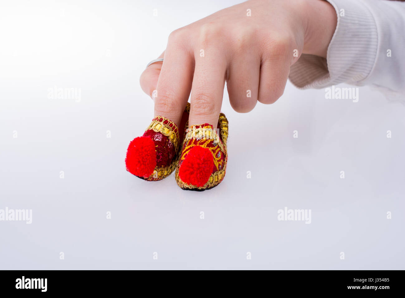 Hand holding traditional Turkish handmade shoes on white background ...