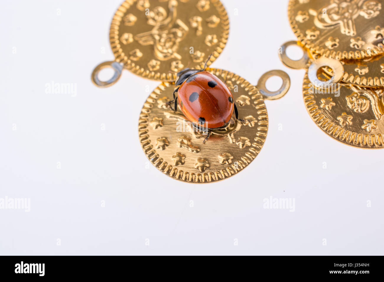 Beautiful photo of red ladybug walking on a fake coins Stock Photo - Alamy