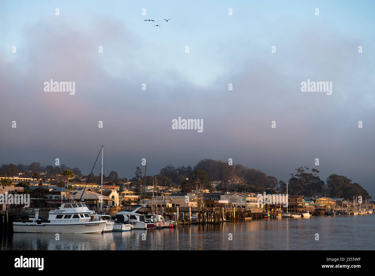 Morro Bay boat docks at sunset. The sky is also red because of wildfire ...