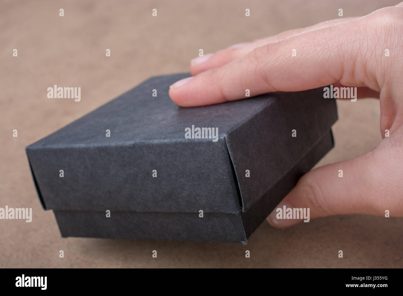 Hand holding a gift box of black color in hand Stock Photo - Alamy