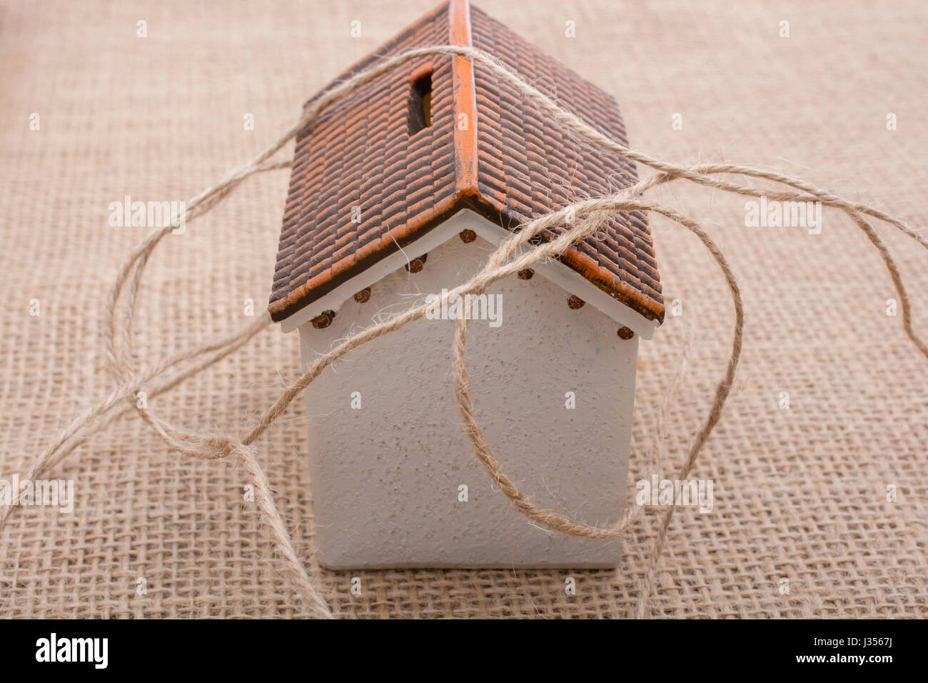 Thread wrapped around a model house on a brown background Stock Photo ...