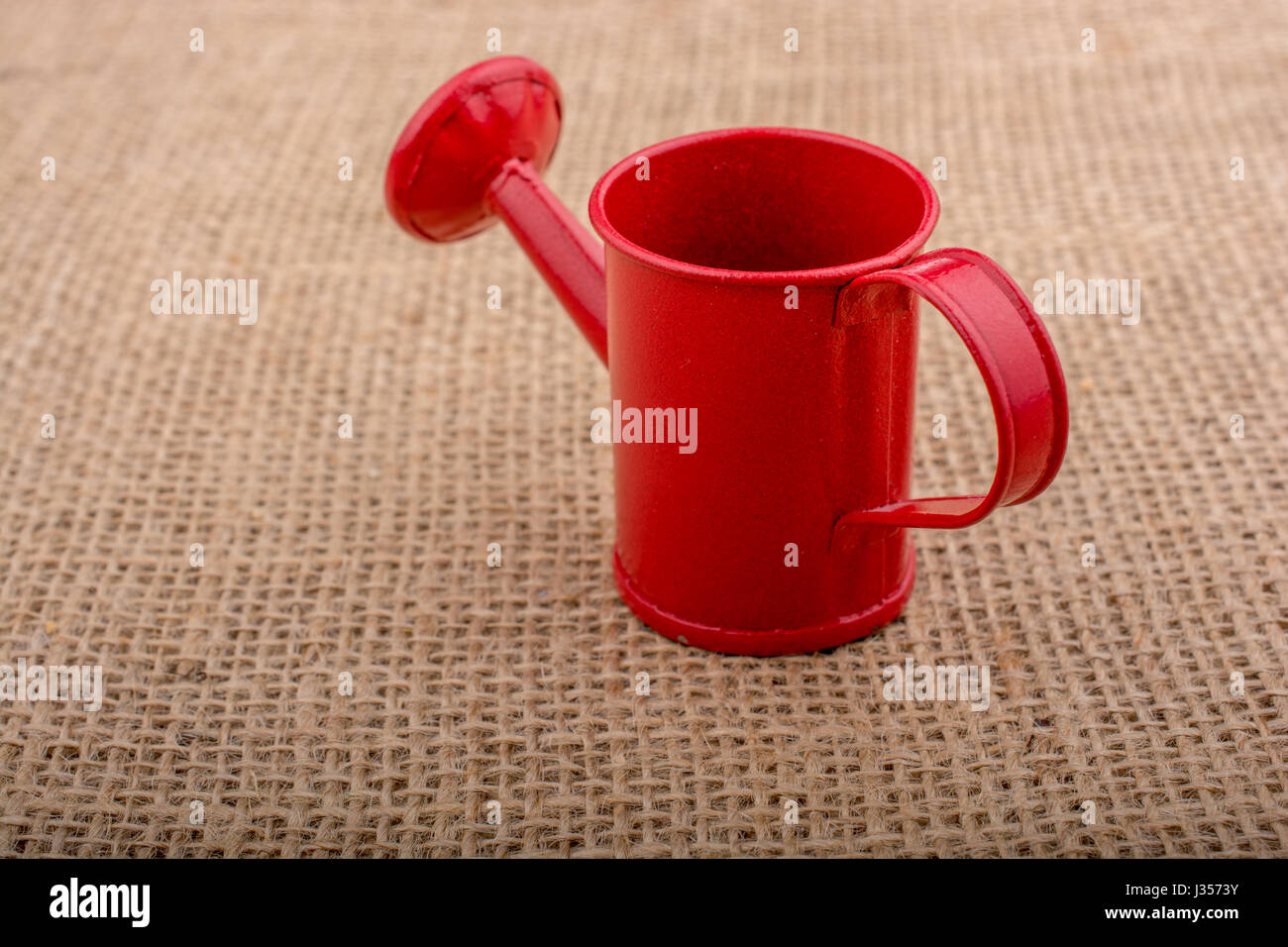 Watering can on a canvas background Stock Photo - Alamy
