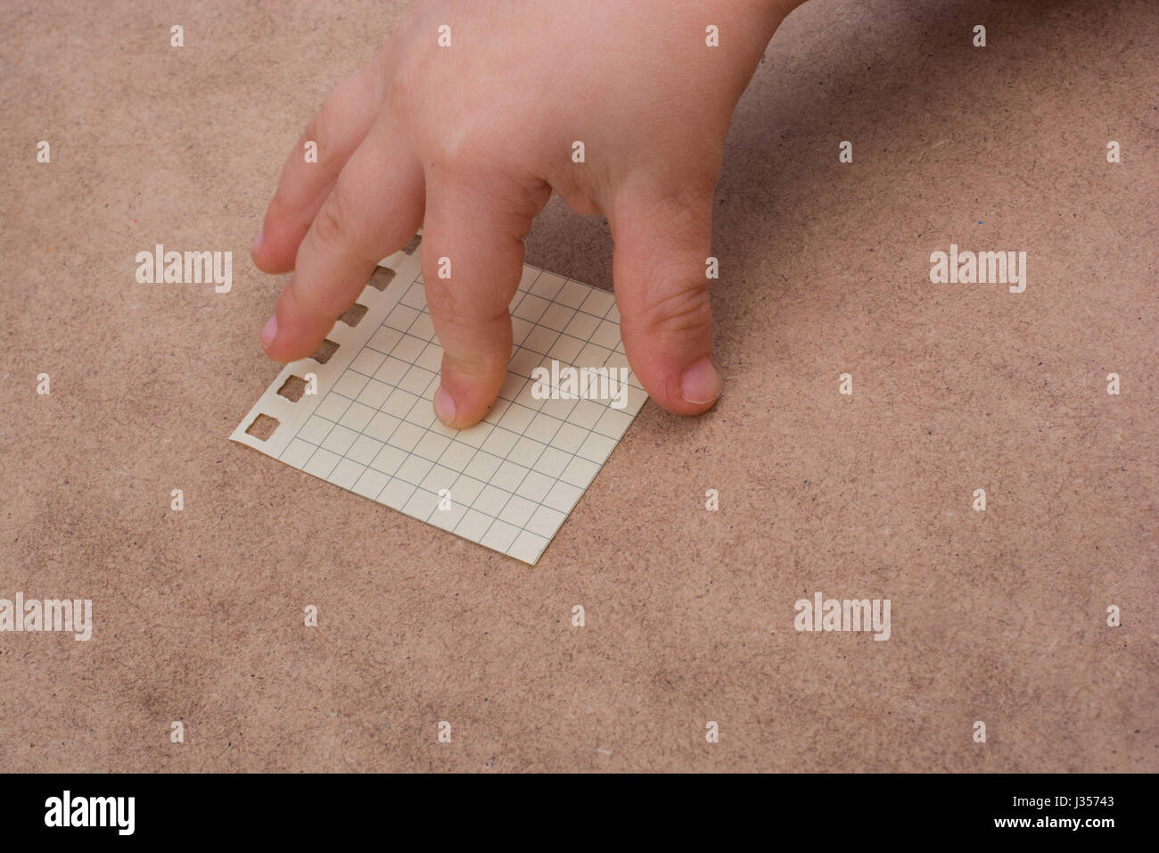 Hand holding a note paper on a brown background Stock Photo - Alamy