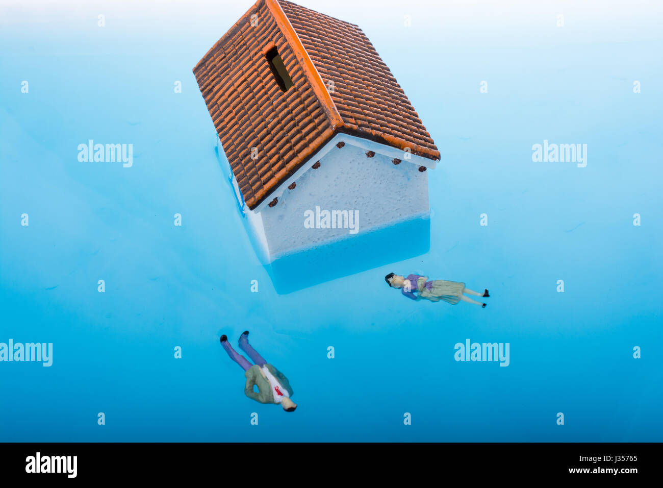Little model house and figurines of man and woman float in water Stock ...