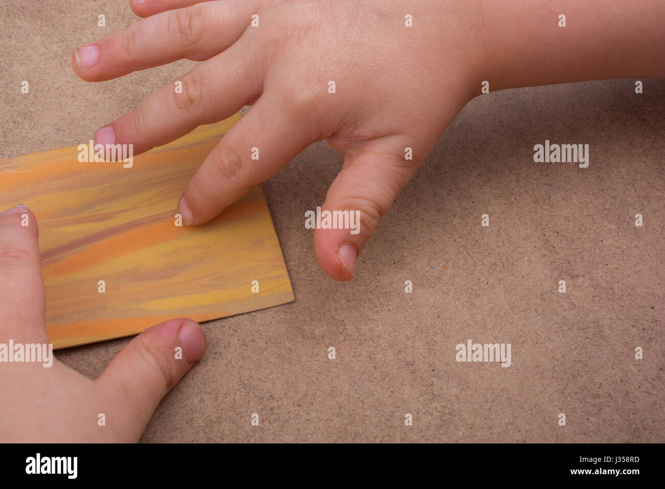 Hand holding painted note paper on brown background Stock Photo - Alamy