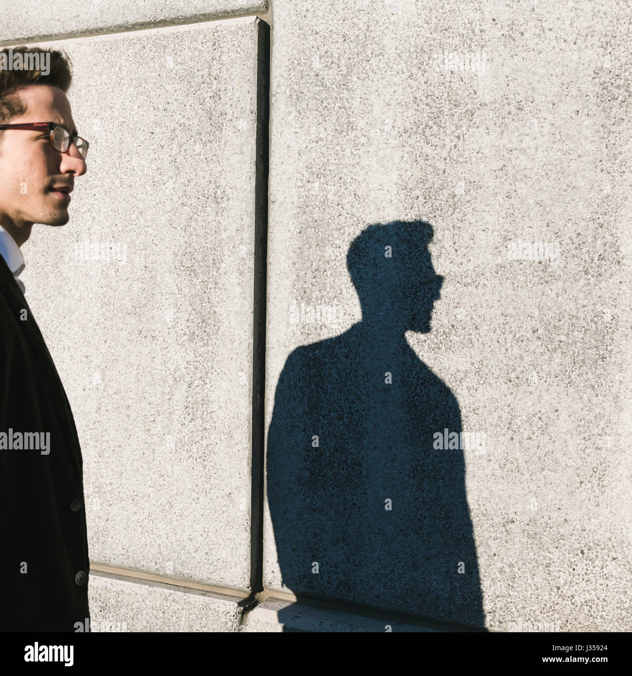Young handsome man with short hair posing in front of his shadow Stock ...