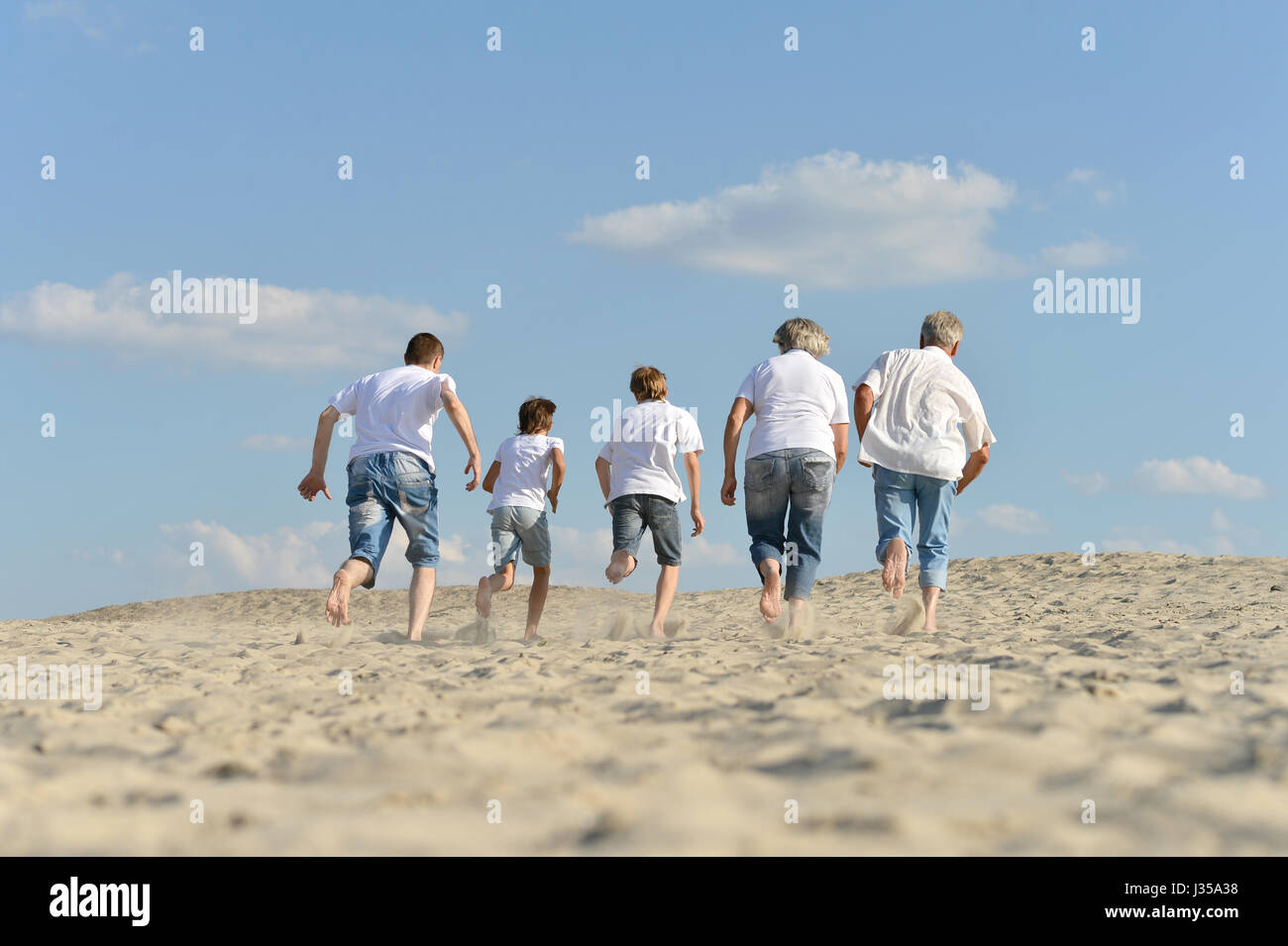 Family running through the sand Stock Photo - Alamy