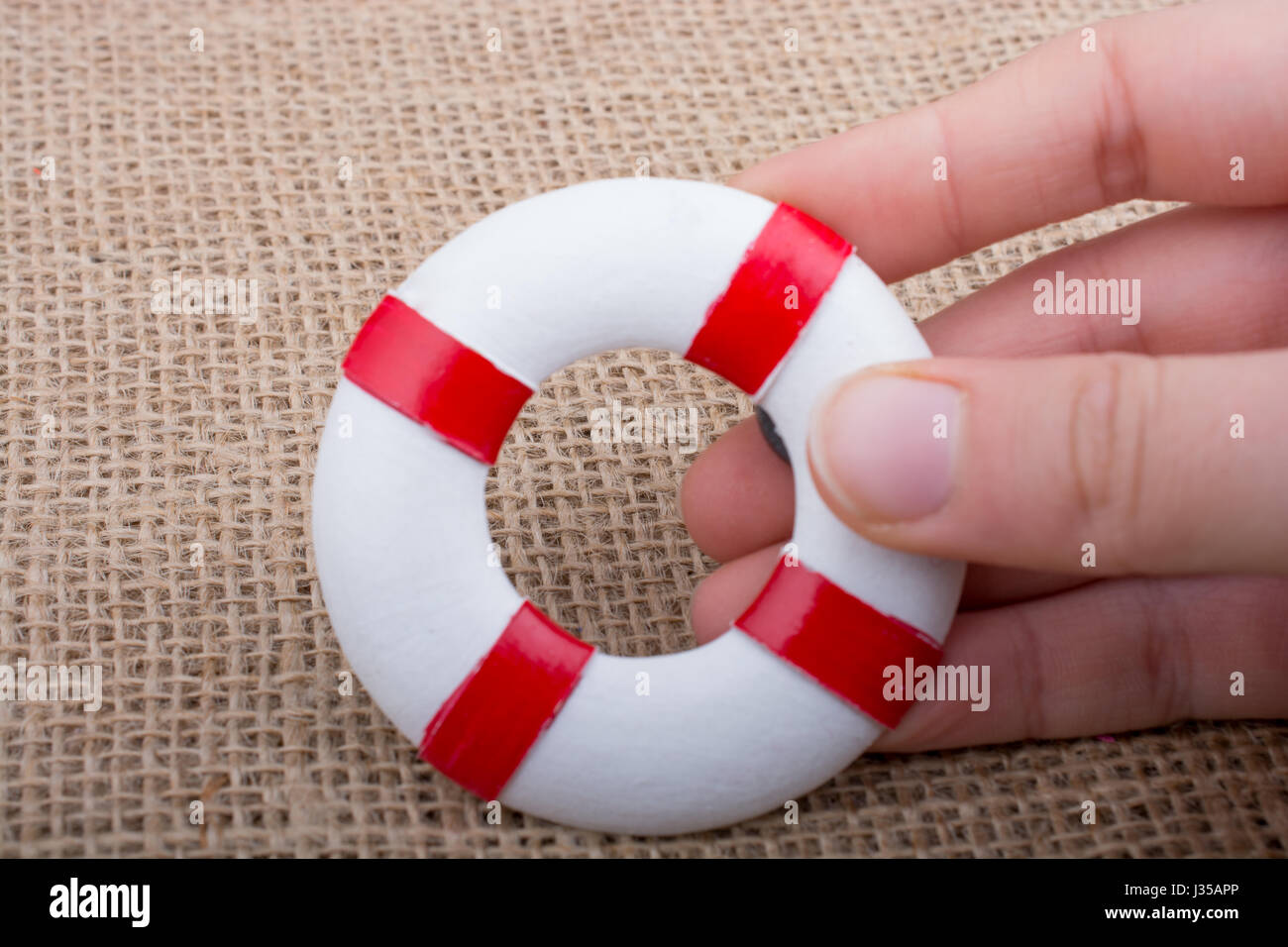 Hand holding a Lifesaver or life preserver on a fabric background Stock ...
